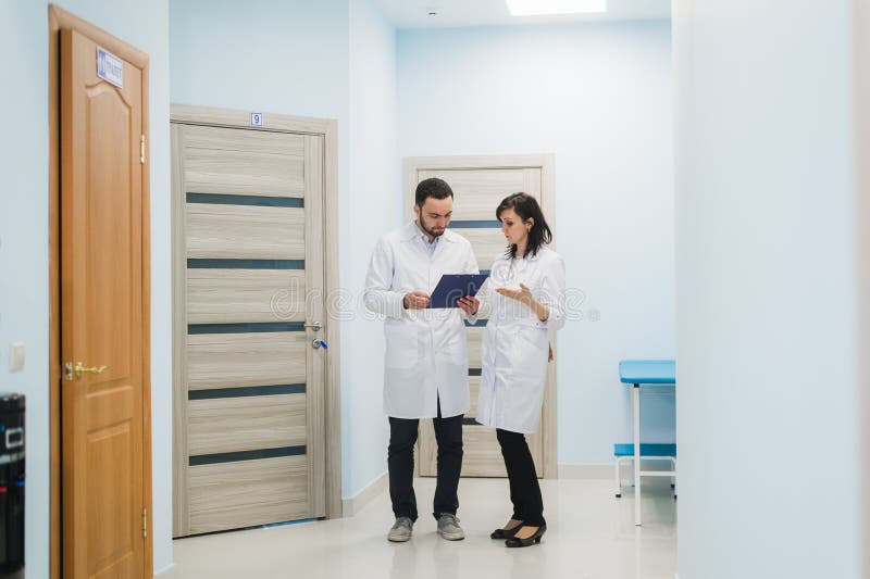 Two Doctors Discussing Diagnosis While Walking Stock Photo - Image of ... Two Doctors Discussing Diagnosis While Walking Stock Photo - Image of ...