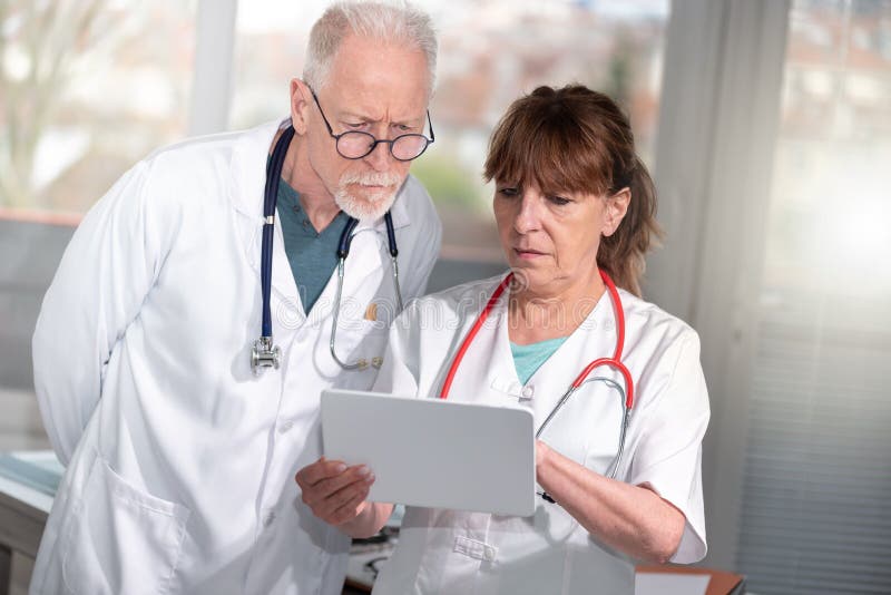Two Doctors Discussing about Medical Report on Digital Tablet Stock ...