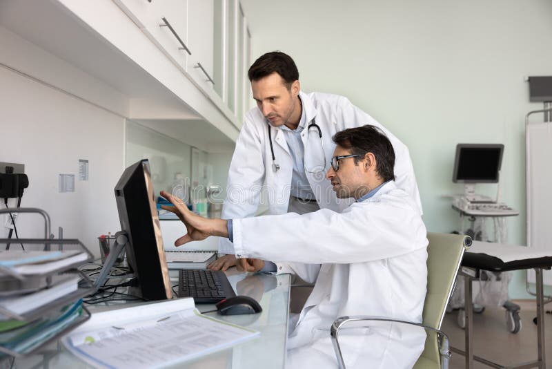 Two Doctors Engaged in Teamwork Using Computer Stock Photo - Image of ...