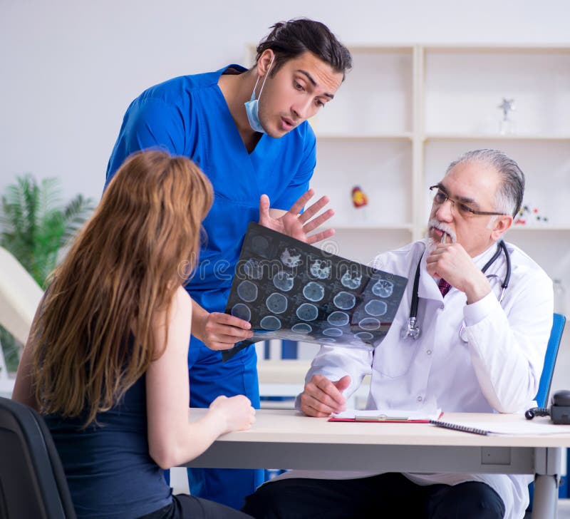 Two Doctors Examining Young Woman Stock Photo - Image of insurance ...