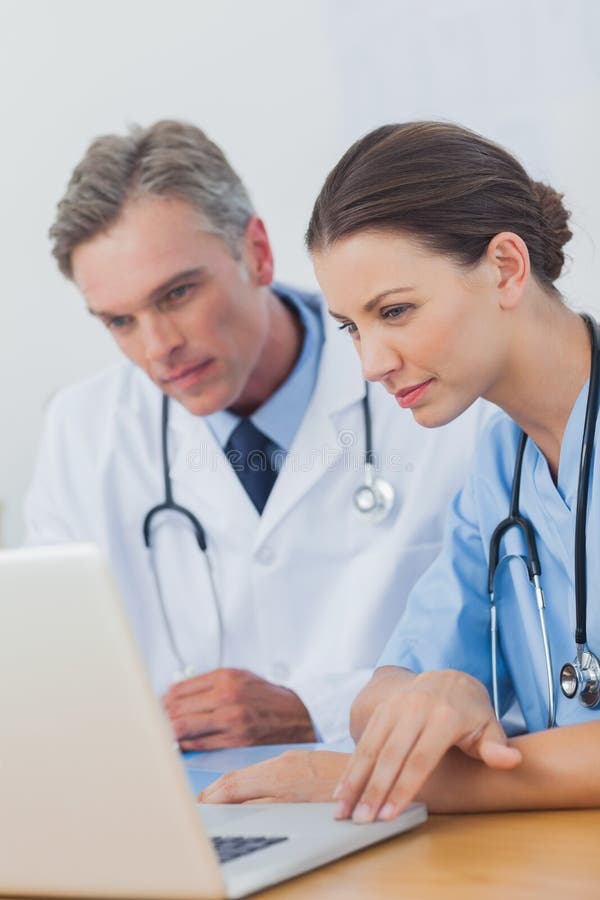Two Doctors Focused on a Laptop Screen Stock Photo - Image of looking ...