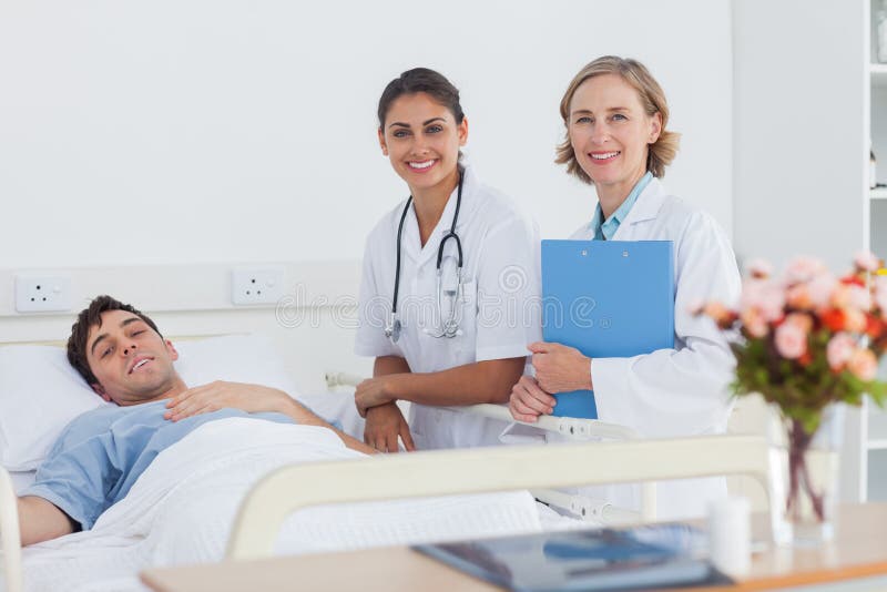 Two Doctors and a Patient Looking at the Camera Stock Image - Image of ...