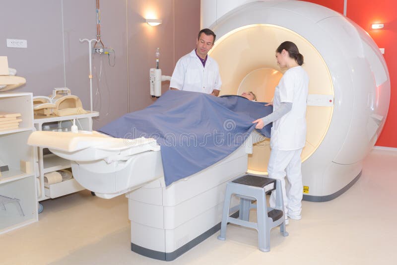Two Doctors Preparing Patient To Ct Scan Procedure Stock Photo - Image ...