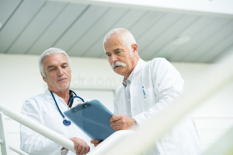 Two Doctors Talking As they Walk through Modern Hospital Stock Image ...