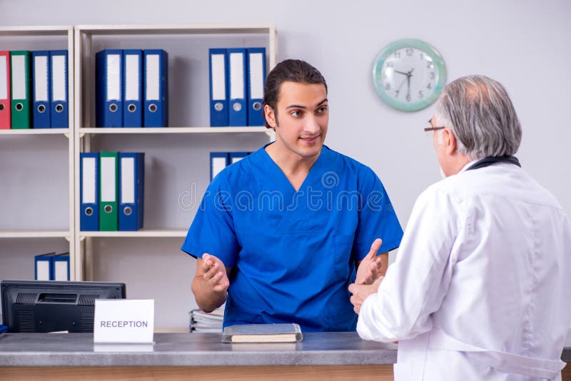 Two Doctors Talking at the Reception in Hospital Stock Image - Image of ...