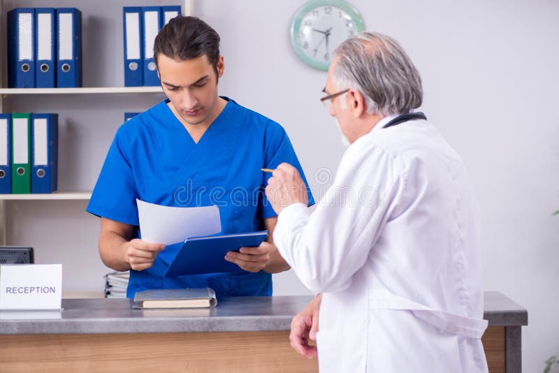 Two Doctors Talking at the Reception in Hospital Stock Photo - Image of ...