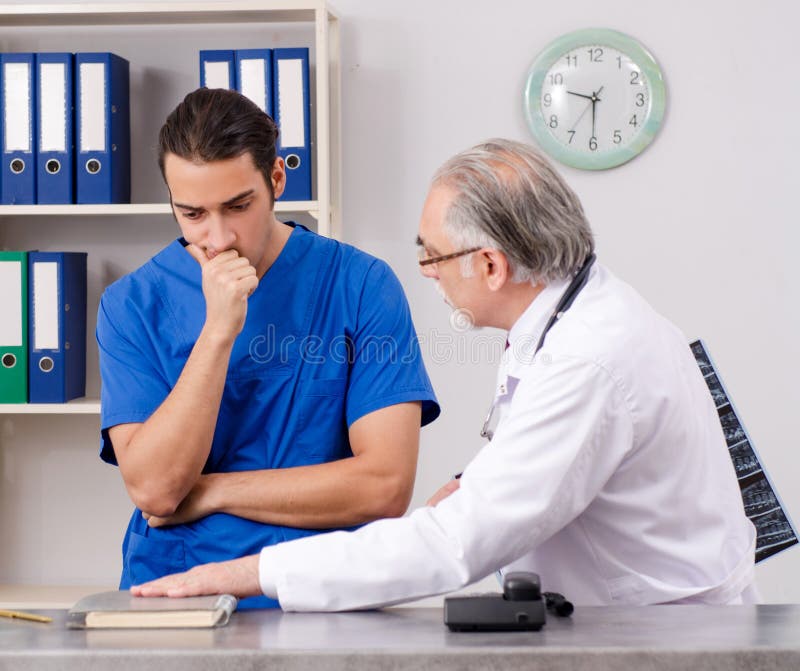 Two Doctors Talking at the Reception in Hospital Stock Photo - Image of ... Two Doctors Talking at the Reception in Hospital Stock Photo - Image of ...