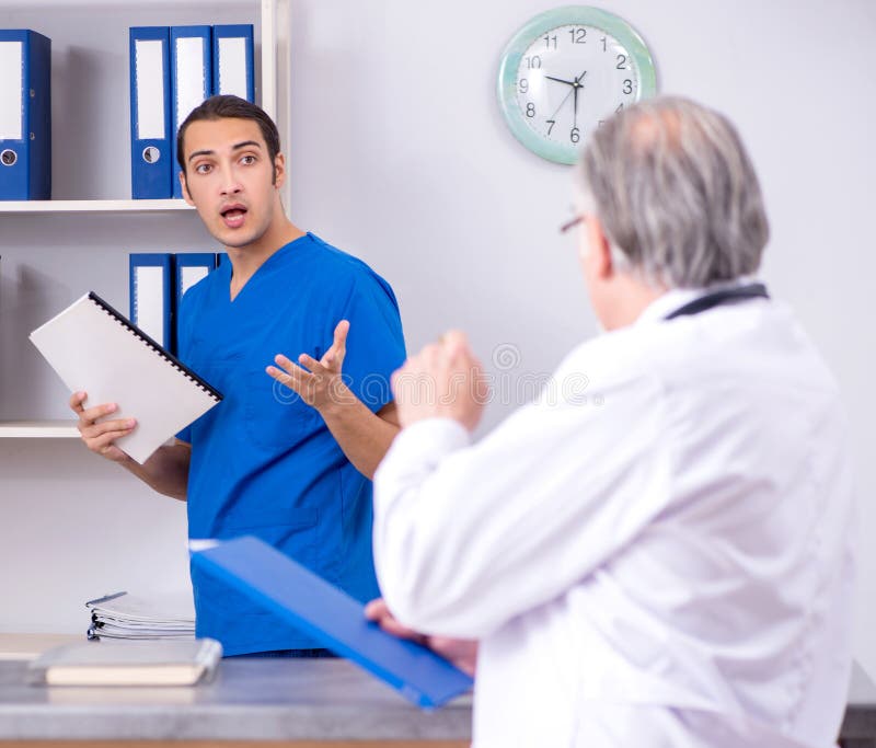 Two Doctors Talking at the Reception in Hospital Stock Photo - Image of ...