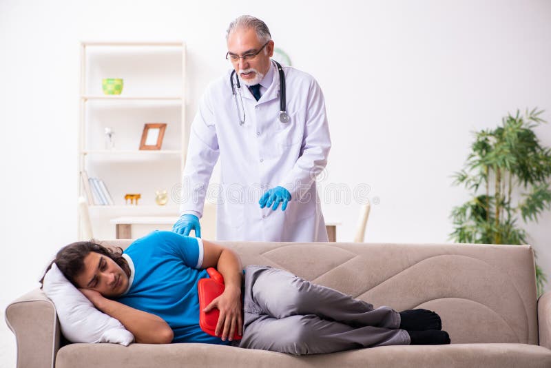Two Doctors Visiting Sick Young Man at Home Stock Image - Image of ...