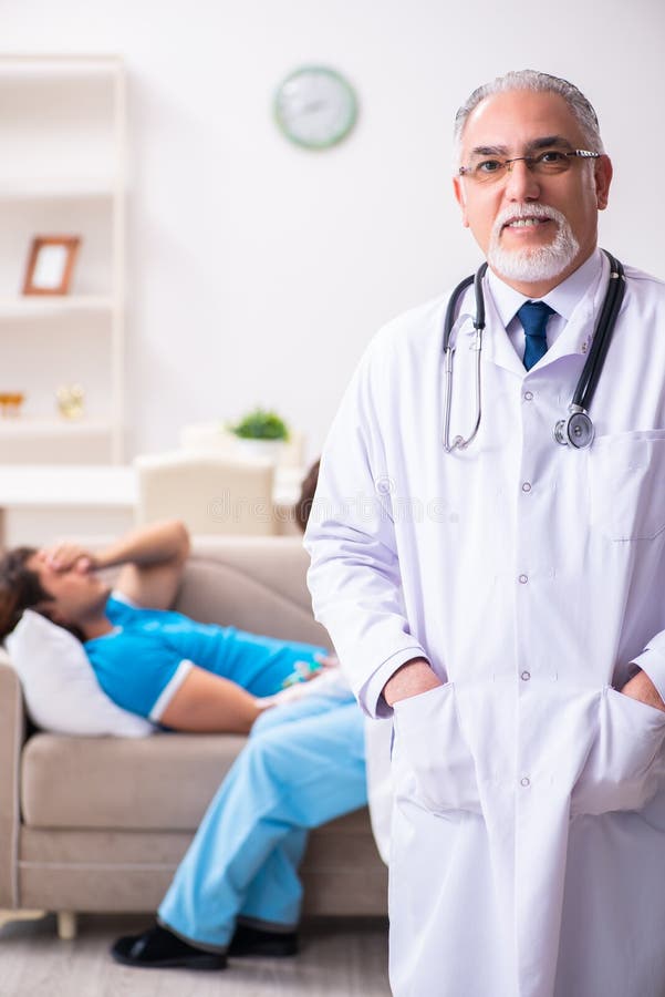 Two Doctors Visiting Sick Young Man at Home Stock Photo - Image of ...
