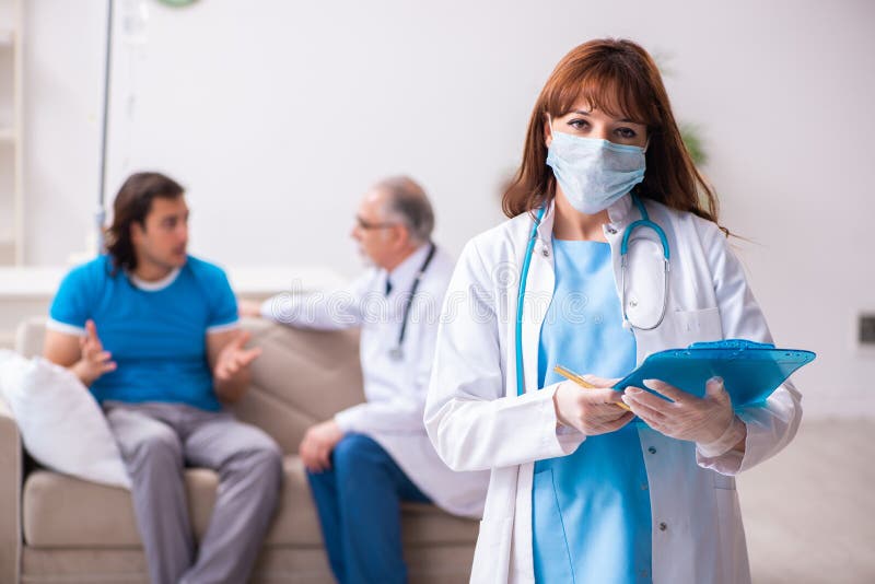 Two Doctors Visiting Sick Young Man at Home Stock Image - Image of ...