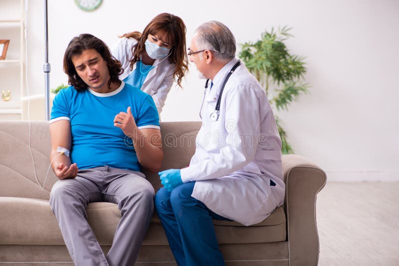 Two Doctors Visiting Sick Young Man at Home Stock Image - Image of drip ...