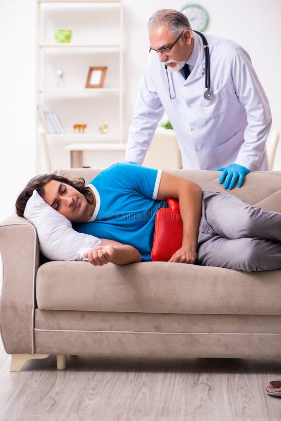 Two Doctors Visiting Sick Young Man at Home Stock Image - Image of ...