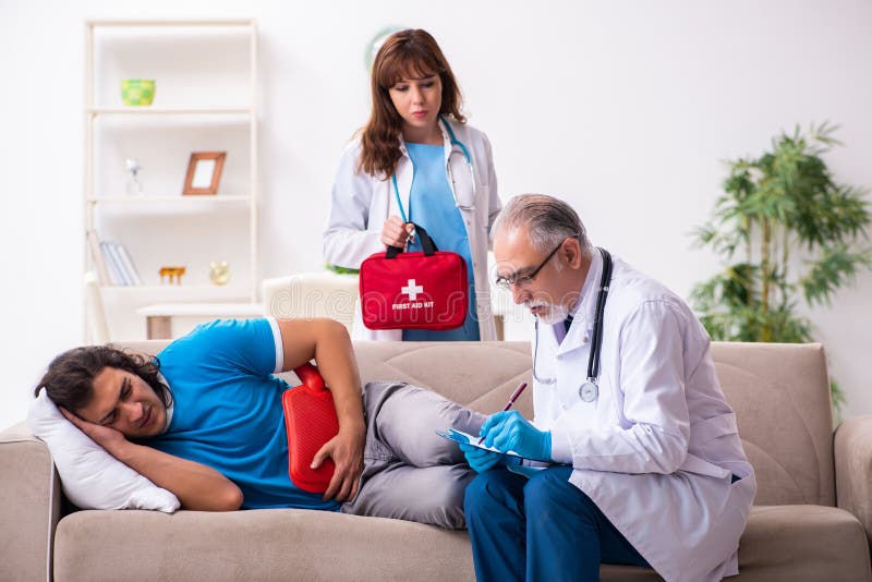 Two Doctors Visiting Sick Young Man at Home Stock Photo - Image of ...