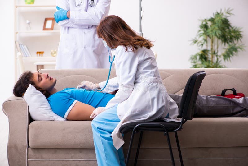Two Doctors Visiting Sick Young Man at Home Stock Image - Image of home ...