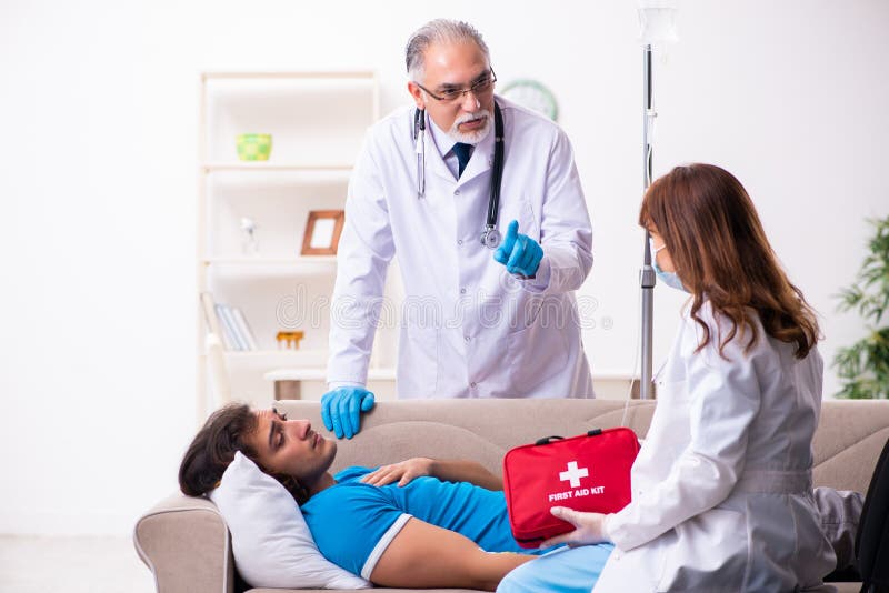 Two Doctors Visiting Sick Young Man at Home Stock Image - Image of ...