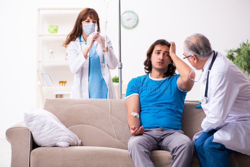 Two Doctors Visiting Sick Young Man at Home Stock Image - Image of ...