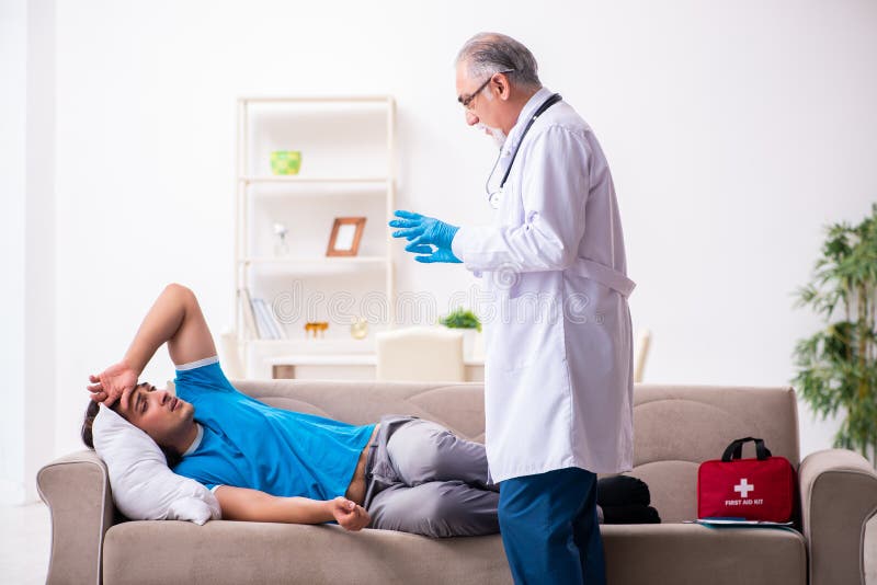 Two Doctors Visiting Sick Young Man at Home Stock Photo - Image of ...