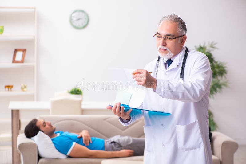 Two Doctors Visiting Sick Young Man at Home Stock Photo - Image of ...