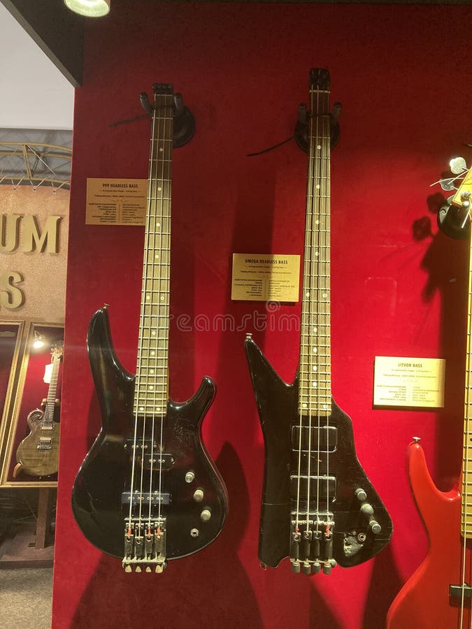 Two Double Bass Guitars in a Red Display, Side by Side, with White Tags ...