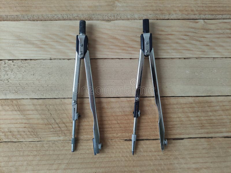 Two Drawing Compasses on the Wooden Background Stock Image - Image of ...