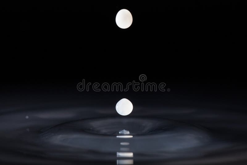 Falling Drop of Milk on a Black Background Stock Photo - Image of ...