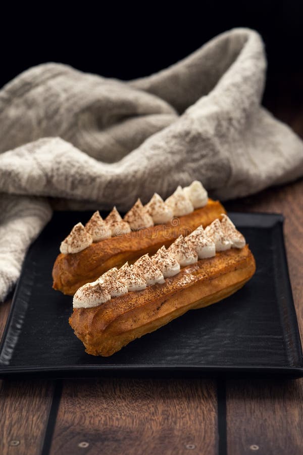 Eclairs with Black Chocolate and White Chocolate with Custard on Rustic ...