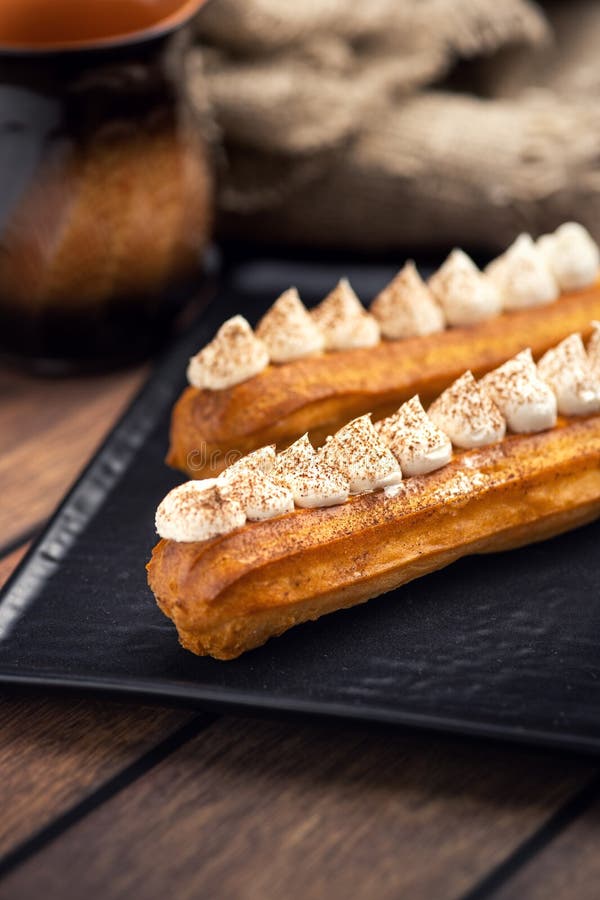 Eclairs with Black Chocolate and White Chocolate with Custard on Rustic ...