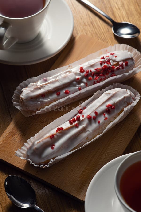 Two Eclairs White Icing Red Sprinkles Wooden Board Accompanied Cup Tea ...
