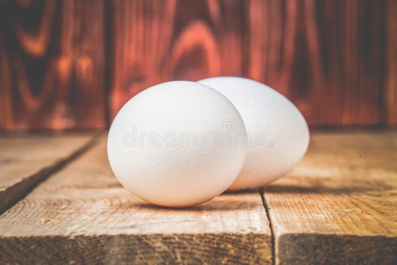 Two eggs on wooden table. stock image. Image of protein - 110964315