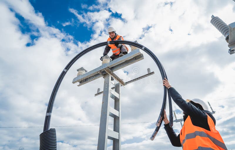 Two Electrician Builder Workers Installing High-voltage Cable Stock ...