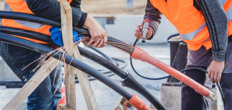 Two Electrician Builder Workers Installing High-voltage Cable Stock ...