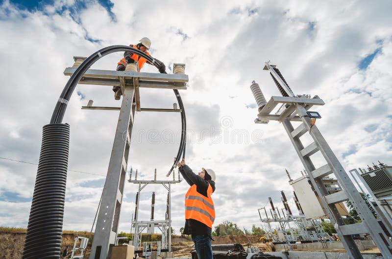 Two Electrician Builder Workers Installing High-voltage Cable Stock ...