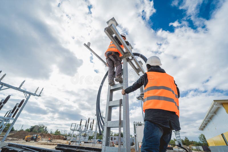 Two Electrician Builder Workers Installing High-voltage Cable Stock ...