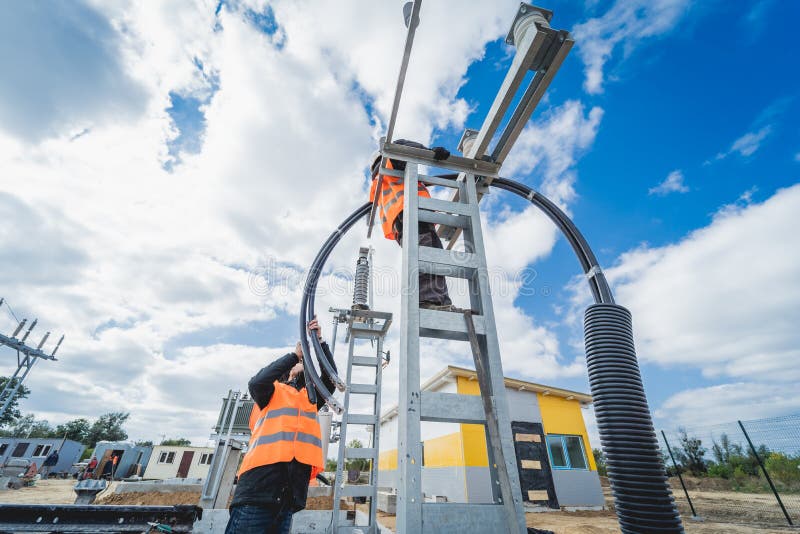Two Electrician Builder Workers Installing High-voltage Cable Stock ...
