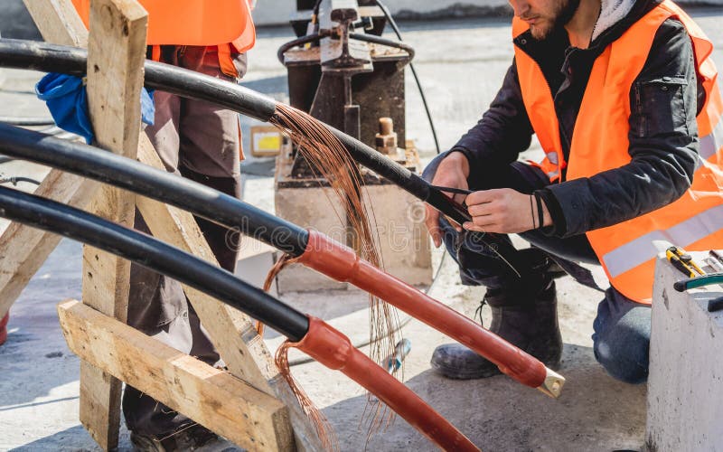 Two Electrician Builder Workers Installing High-voltage Cable Stock ...