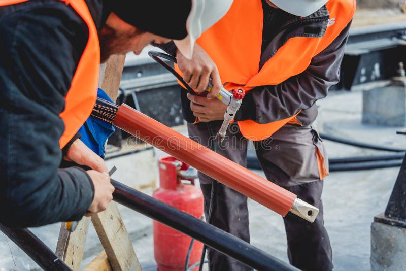 Two Electrician Builder Workers Installing High-voltage Cable Stock ...