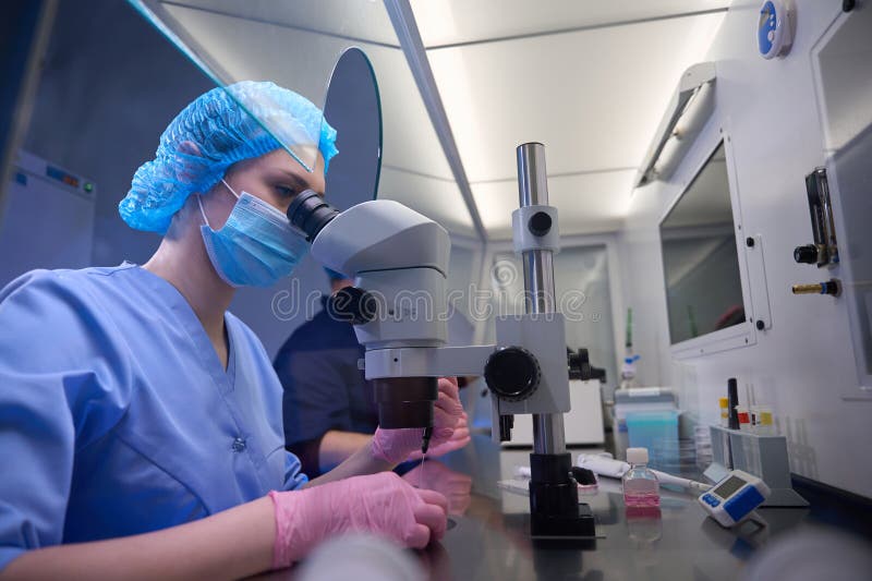 Doctors Using a Microscope and Lab Equipment for a Procedure Stock ...
