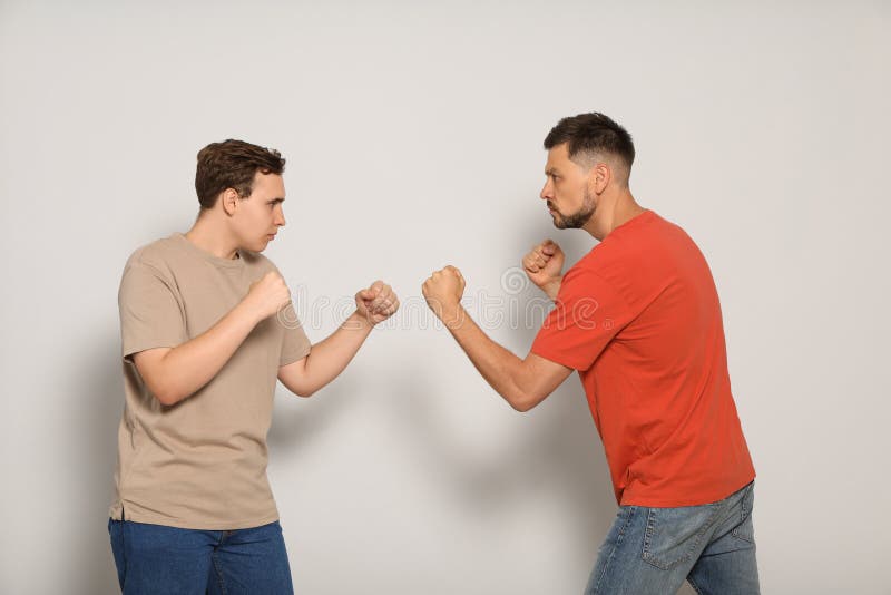Two Emotional Men Fighting on Light Blue Background Stock Photo - Image ...