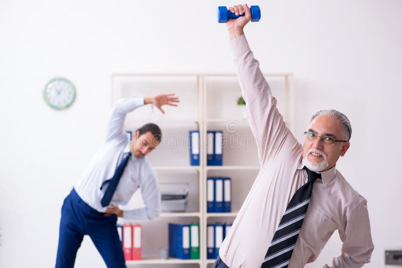 Two Employees Doing Physical Exercises at Workplace Stock Photo - Image ...