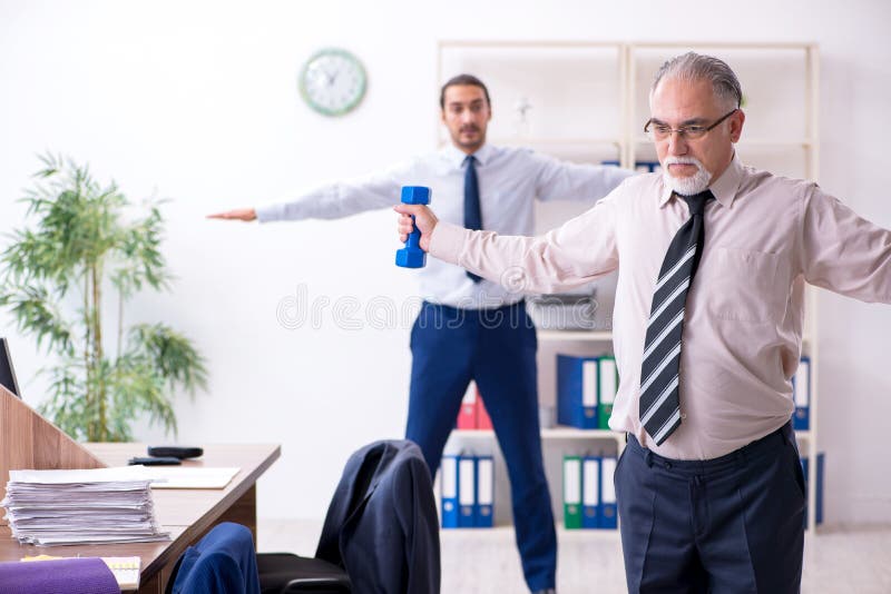 Two Employees Doing Physical Exercises at Workplace Stock Image - Image ...