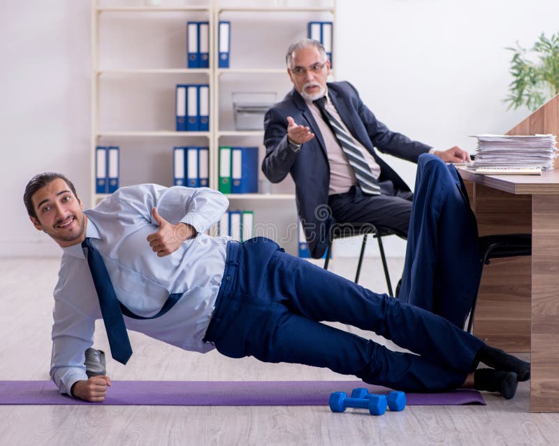 Two Employees Doing Physical Exercises at Workplace Stock Image - Image ...