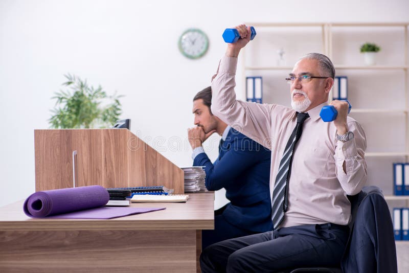 Two Employees Doing Physical Exercises at Workplace Stock Photo - Image ...