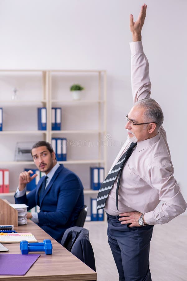 Two Employees Doing Physical Exercises at Workplace Stock Image - Image ...