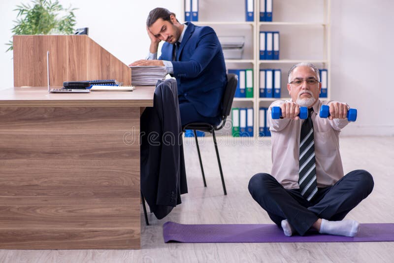 Two Employees Doing Physical Exercises at Workplace Stock Image - Image ...
