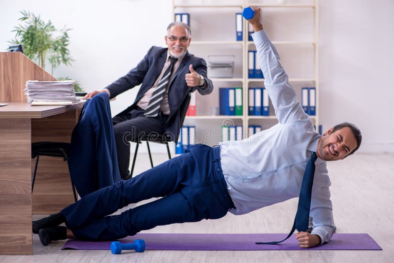 Two Employees Doing Physical Exercises at Workplace Stock Photo - Image ...