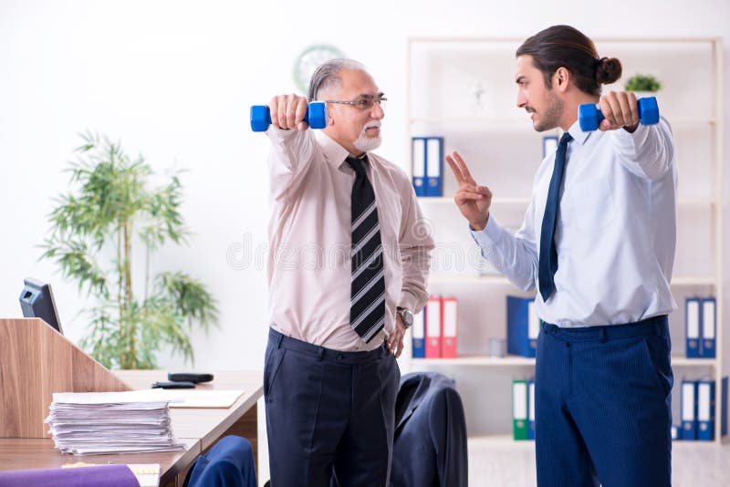 Two Employees Doing Physical Exercises at Workplace Stock Photo - Image ...
