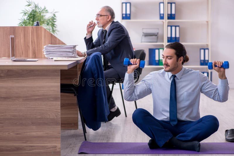 Two Employees Doing Physical Exercises at Workplace Stock Photo - Image ...