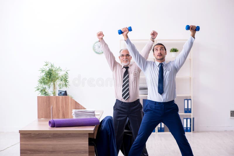Two Employees Doing Physical Exercises at Workplace Stock Photo - Image ...