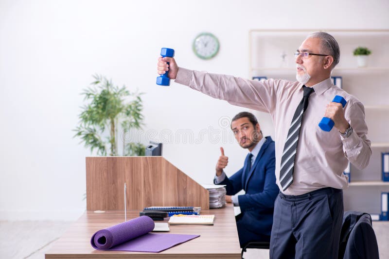 Two Employees Doing Physical Exercises at Workplace Stock Photo - Image ...